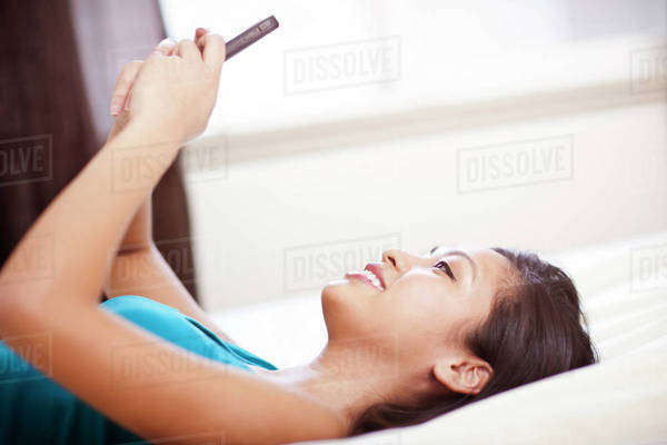 Pacific Islander woman text messaging on cell phone - Royalty-free ...