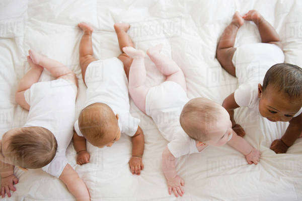 Babies laying on floor together - Royalty-free Stock Photo | Dissolve
