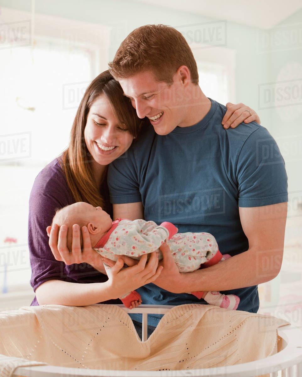 Caucasian parents holding baby girl - Stock Photo - Dissolve