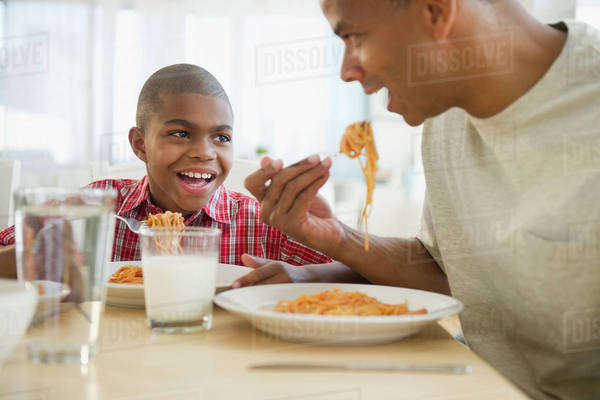 Father and son eating dinner - Royalty-free Stock Photo | Dissolve