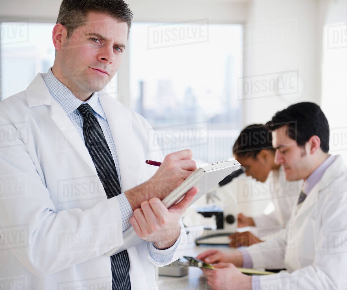 Scientist writing on clipboard in laboratory - Royalty-free Stock Photo ...