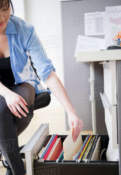 Korean woman removing folder from desk drawer - Royalty-free Stock ...