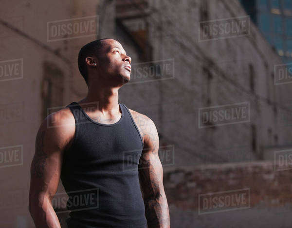 Serious Black man standing outdoors - Stock Photo - Dissolve