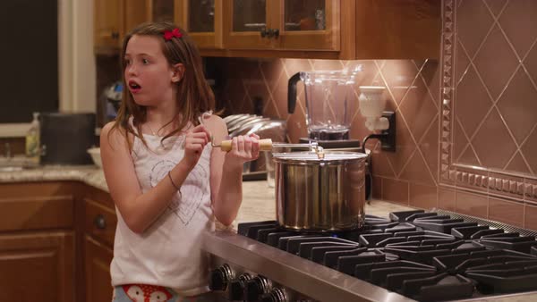 A girl making popcorn on the stove - Stock Video Footage - Dissolve