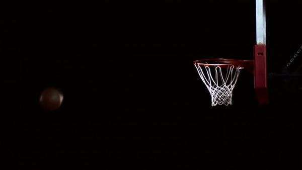 A basketball floats through the air and hits the rim and bounces away ...