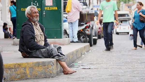 A homeless man sits on the curb in a small town in Mexico - HD Royalty ...