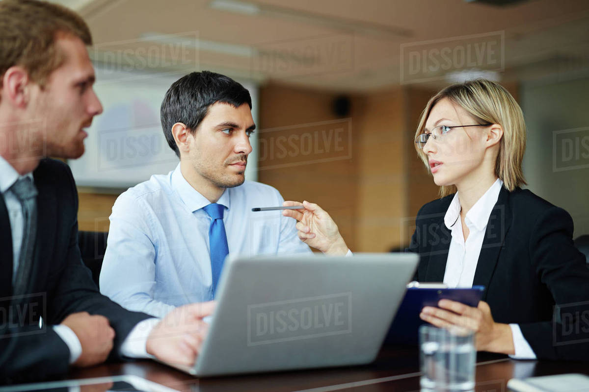 Serious manager explaining her colleagues her point - Stock Photo ...