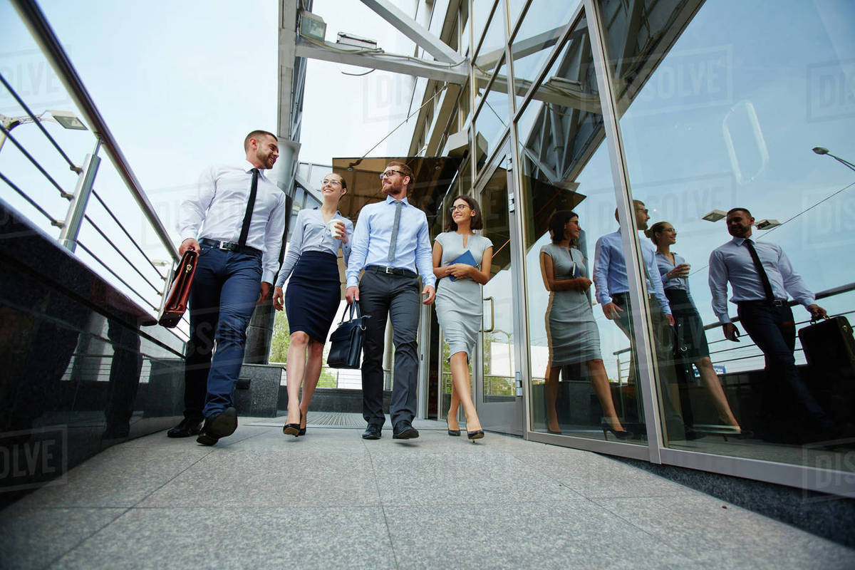 Team of colleagues moving along glass wall - Stock Photo - Dissolve