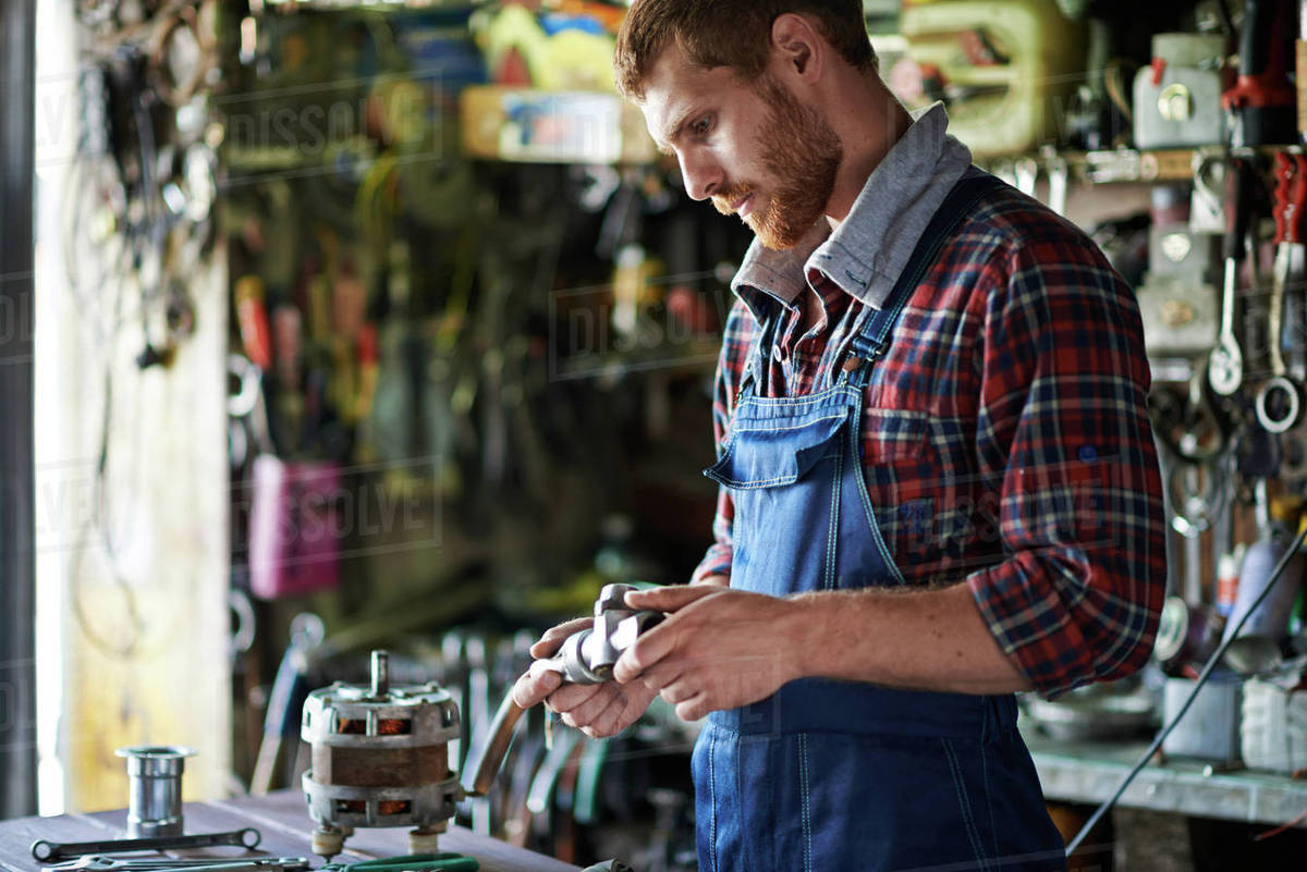 Repairman in uniform working with spare parts - Royalty-free Stock ...