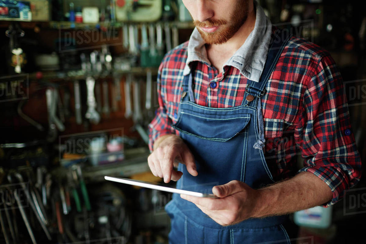 Modern repairman in uniform working on touchpad - Royalty-free Stock ...