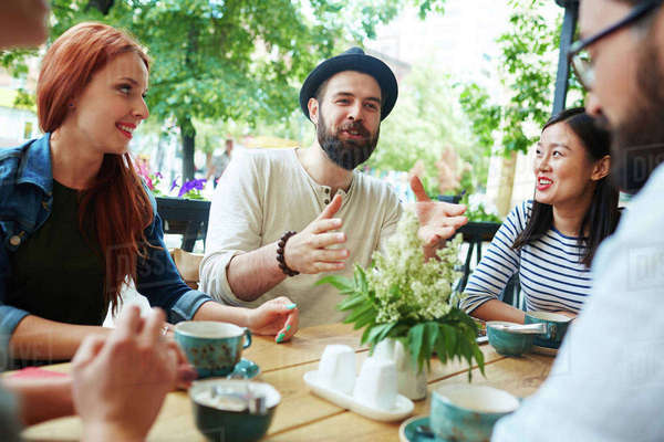 Group of friends communicating at cafe and drinking tea - Royalty-free ...