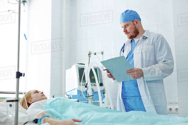 Physician visiting his patient in icu - Royalty-free Stock Photo | Dissolve