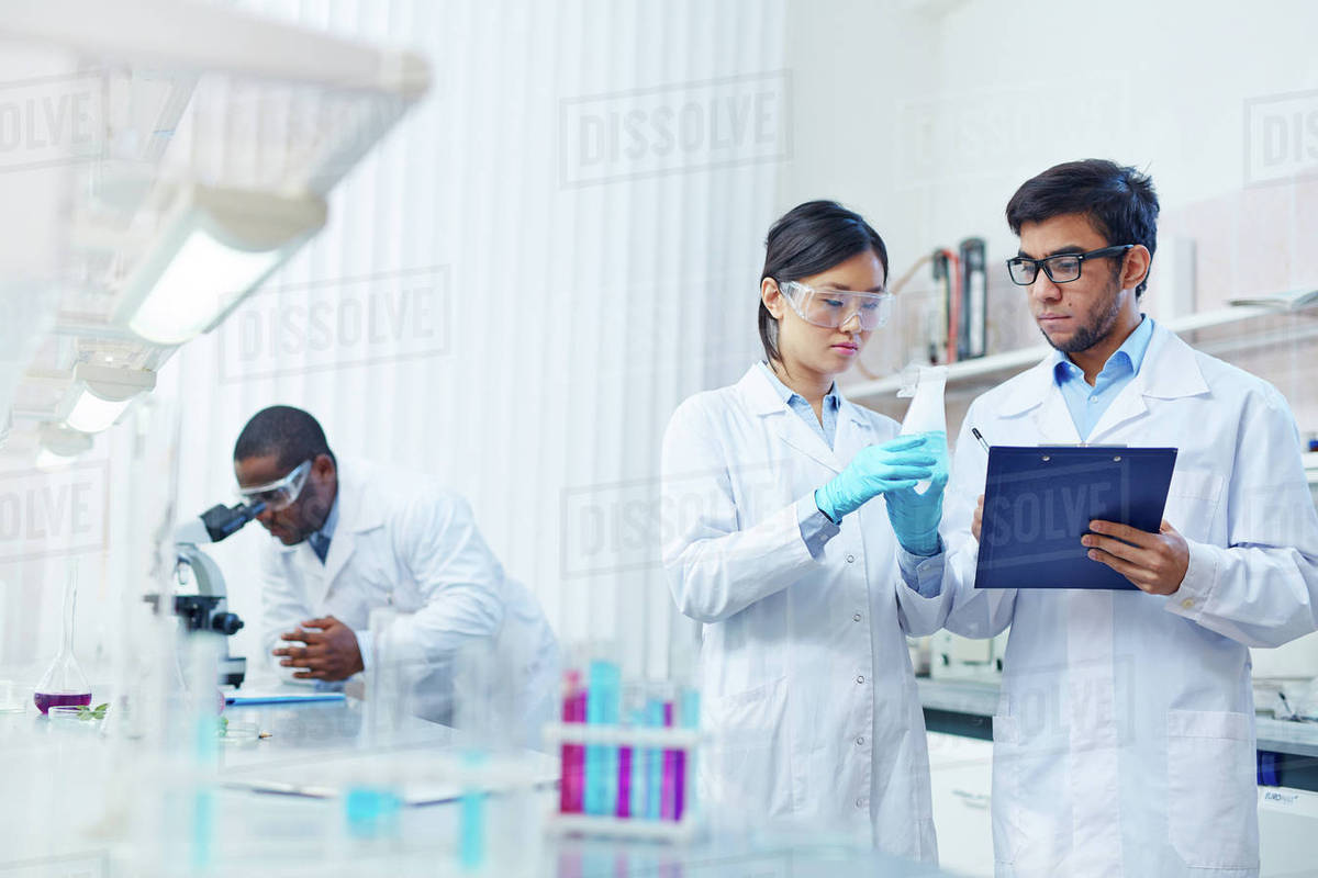 Three scientists working together in a laboratory - Royalty-free Stock ...