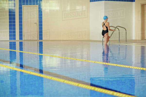 Young woman in swimsuit climbing out of the pool - Royalty-free Stock ...