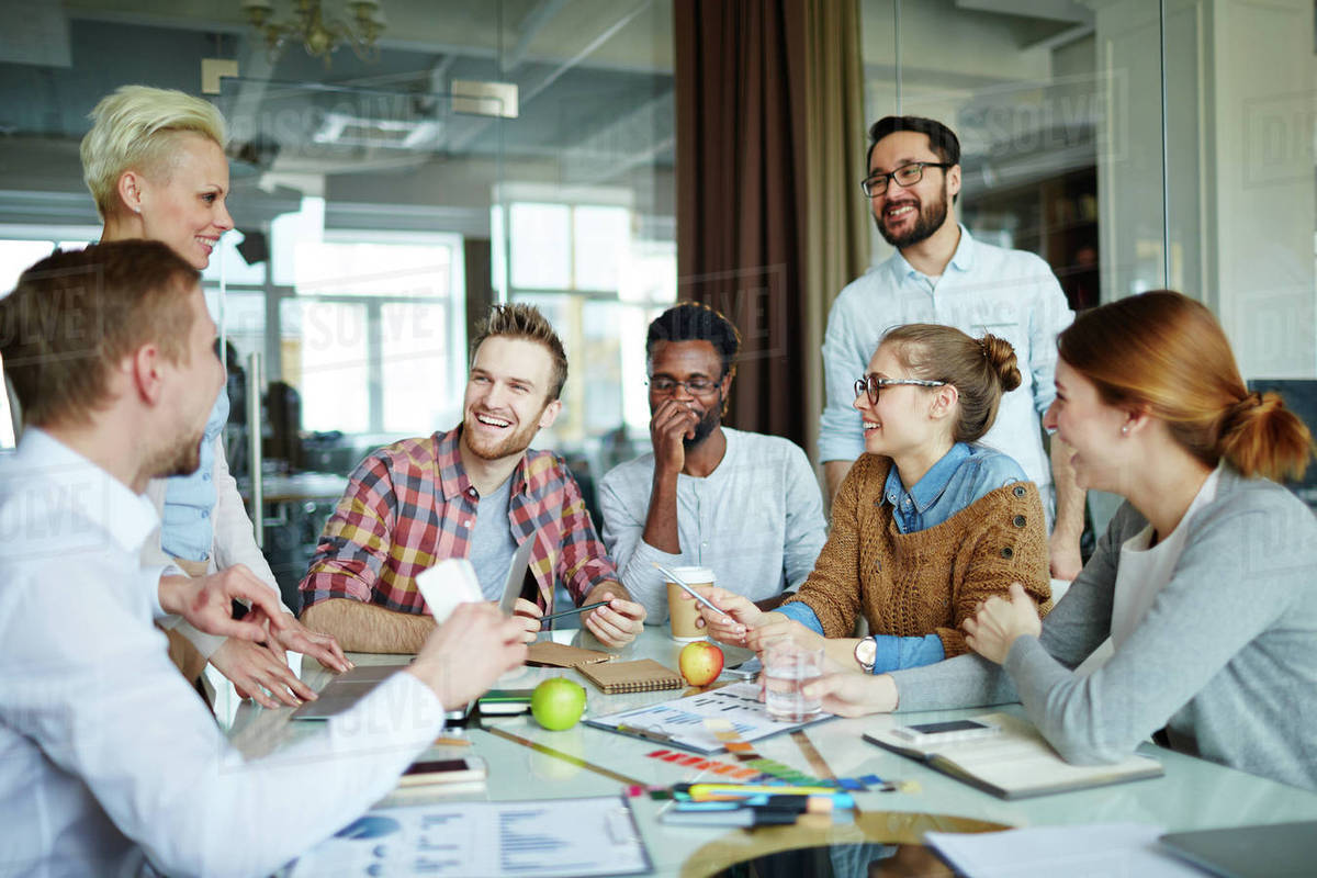 Group of happy colleagues discussing ideas at meeting - Stock Photo ...
