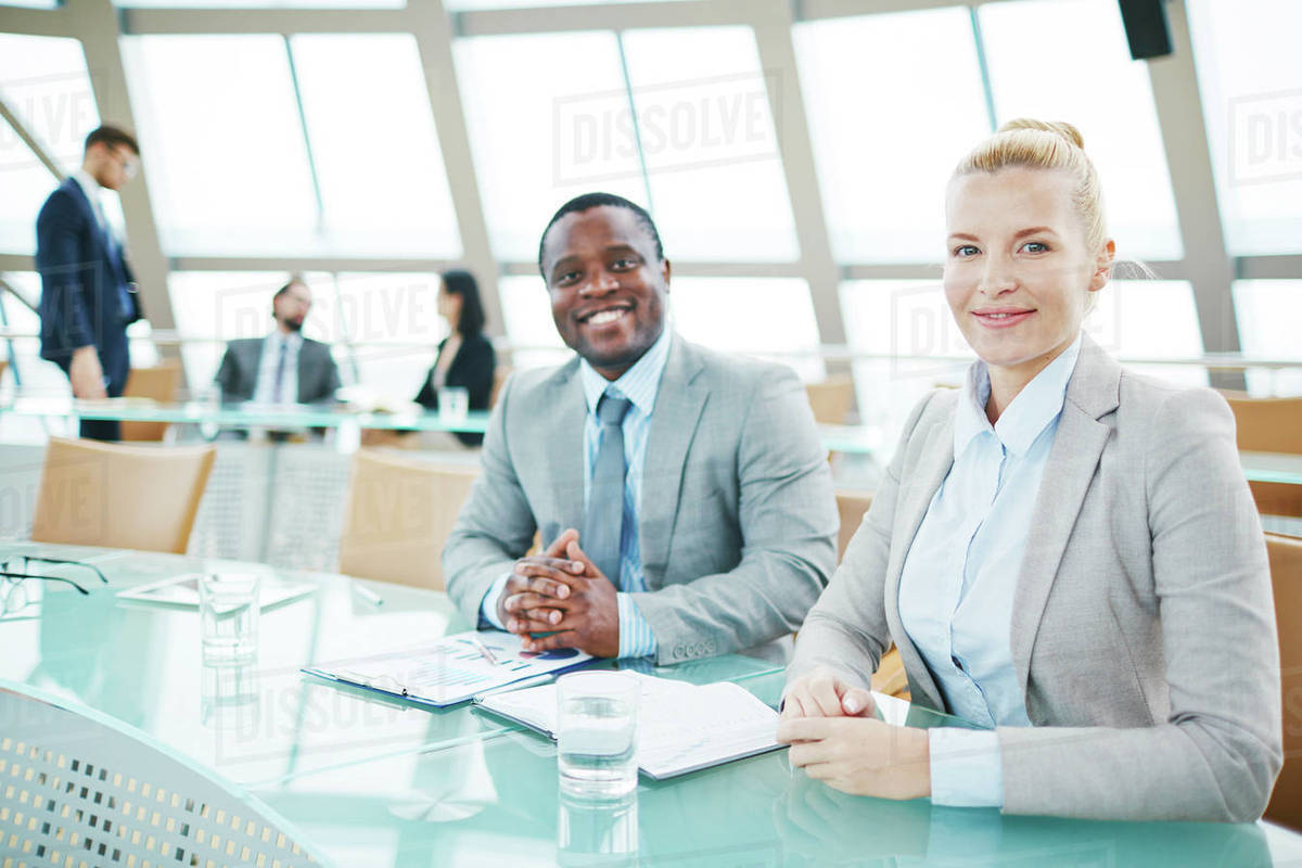 Managers looking at camera in conference hall - Royalty-free Stock ...