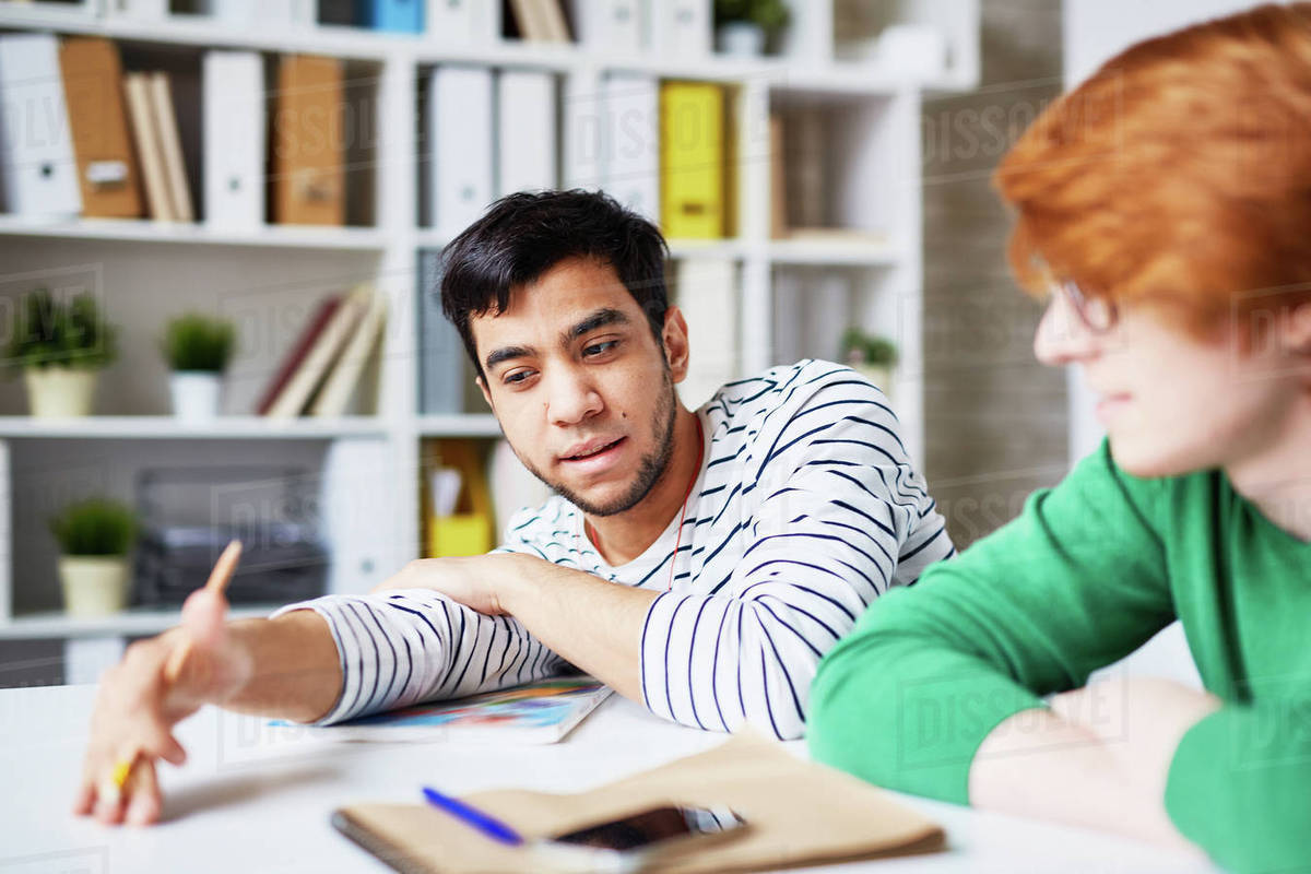 Modern student explaining something to college group mate - Stock Photo ...