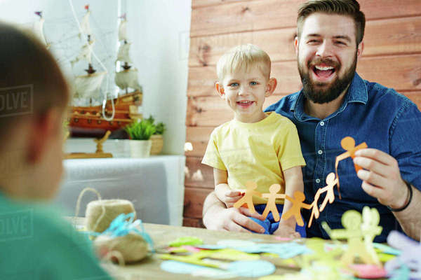 Happy young man with child looking at camera - Stock Photo - Dissolve