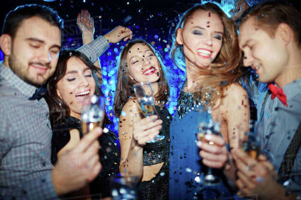 Posh girls and guys with champagne dancing in night club - Royalty-free ...