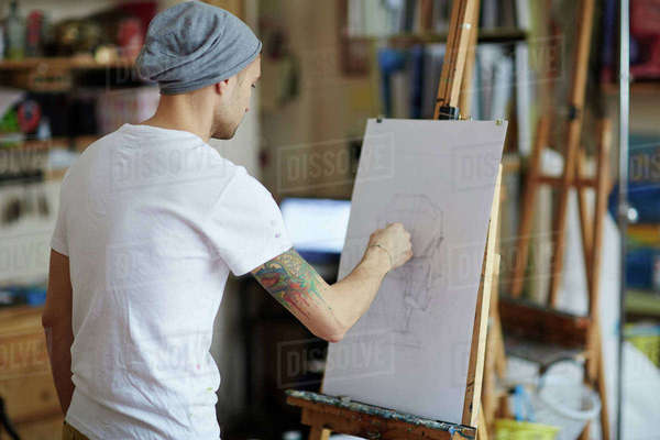 Young man drawing in art studio - Royalty-free Stock Photo | Dissolve