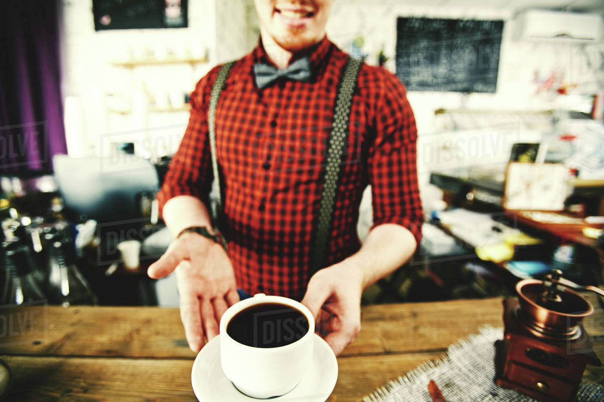 Male barista serving hot coffee - Royalty-free Stock Photo | Dissolve