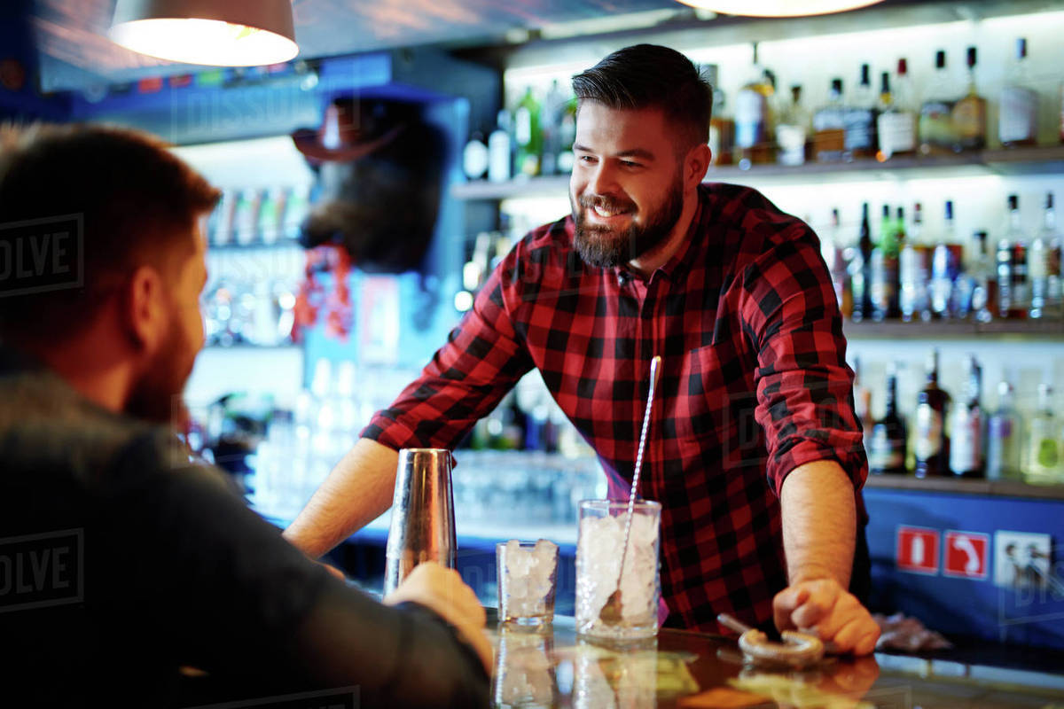 Happy barman looking at client - Stock Photo - Dissolve