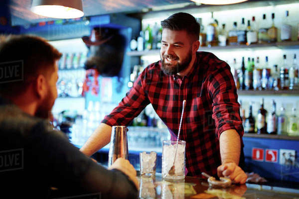 Happy barman looking at client - Stock Photo - Dissolve