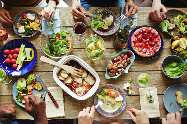 People having a rich dinner with fresh vegetables and homemade meal ...