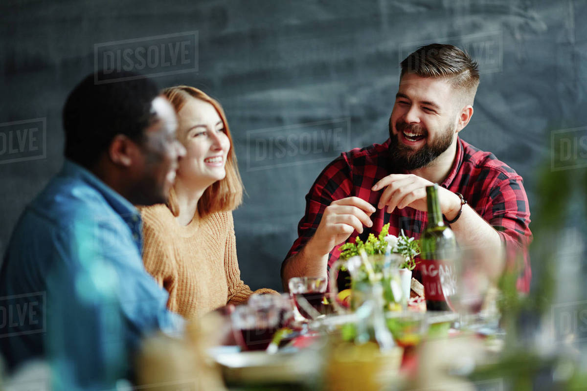 Three friends having dinner together and laughing - Royalty-free Stock ...
