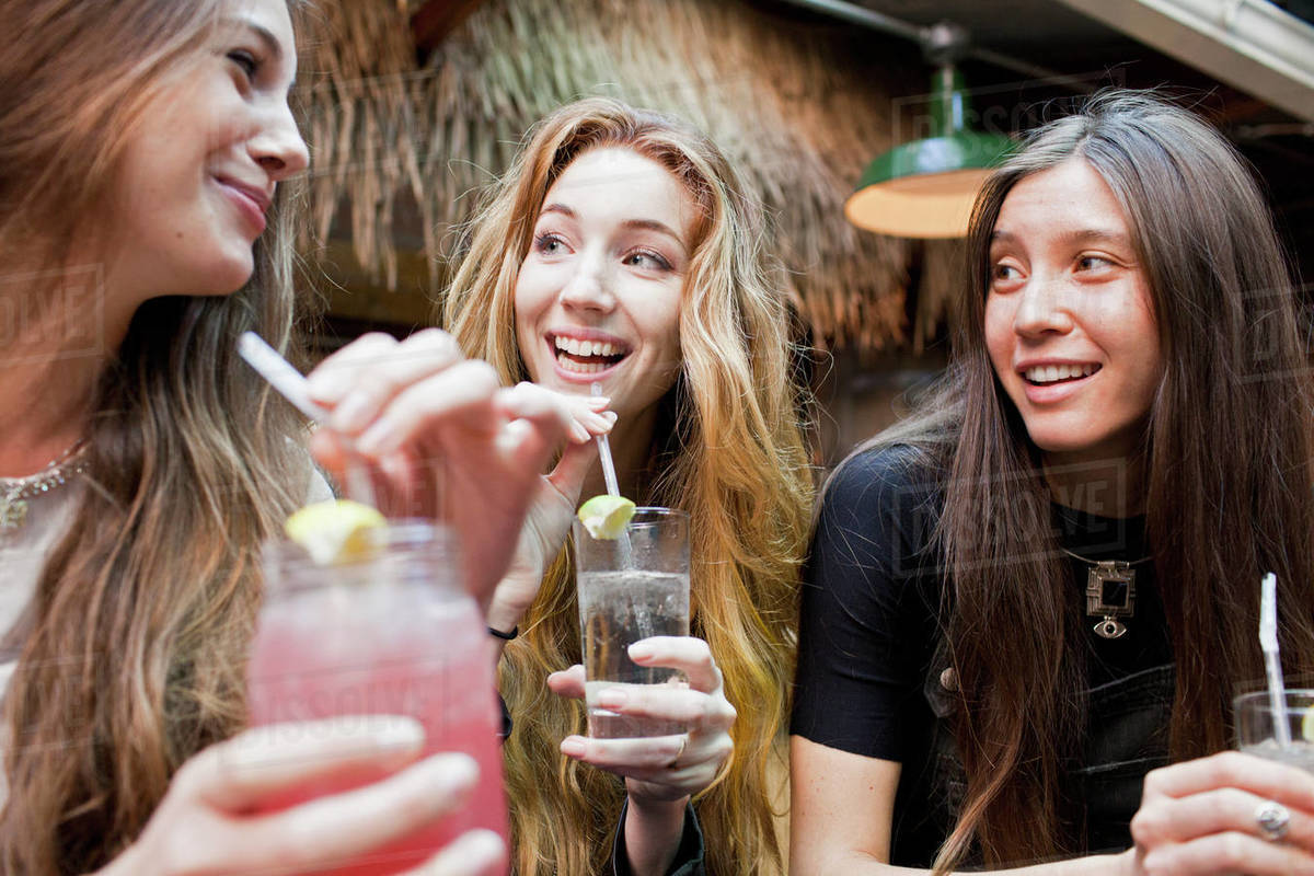 Happy young friends enjoying drinks at a bar - Royalty-free Stock Photo ...