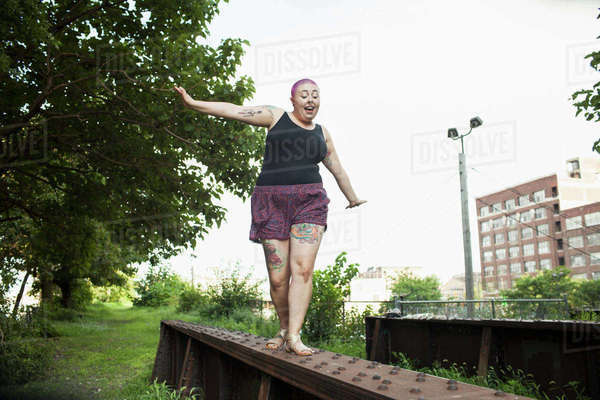 A young woman balancing on a bench - Stock Photo - Dissolve
