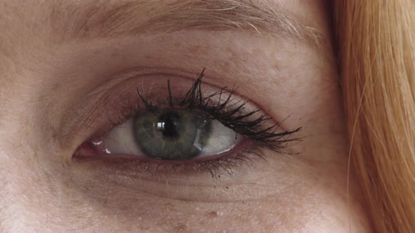 Close up woman eye blinking looking at camera happy red head female ...