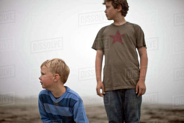 Two brothers standing on beach. - Royalty-free Stock Photo | Dissolve