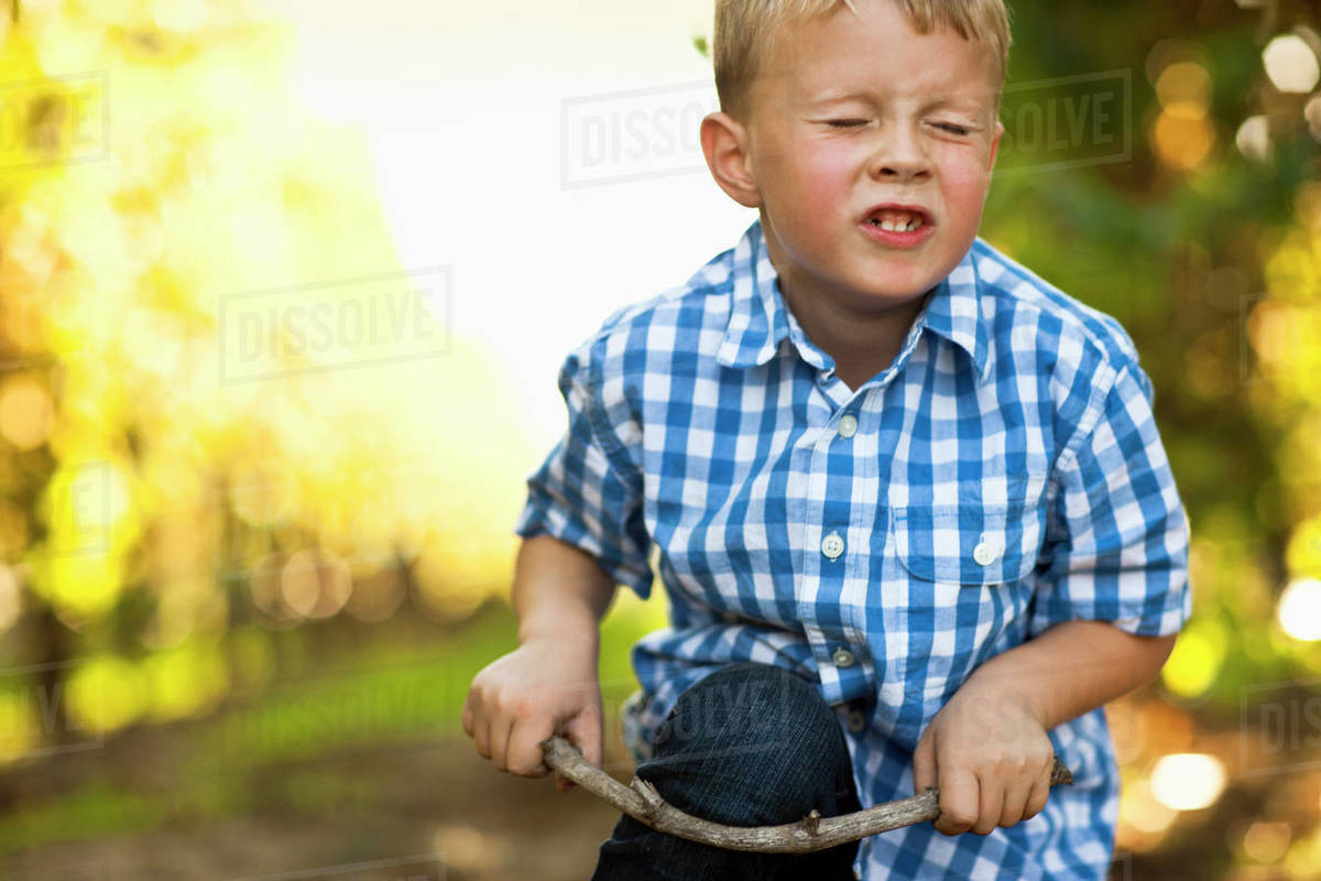 Little boy trying to break the stick with his knee. - Royalty-free ...