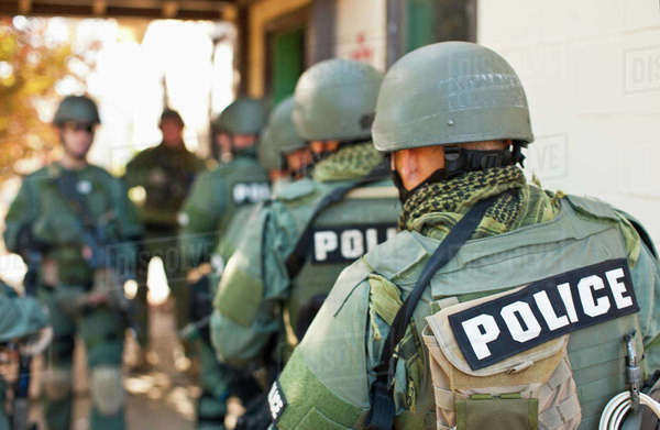 Team of armed military police holding guns while walking together in a ...
