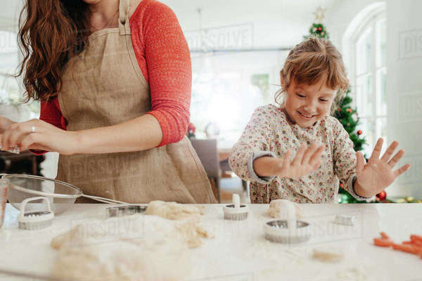 Little girl having fun making cookies. Woman with her daughter making ...