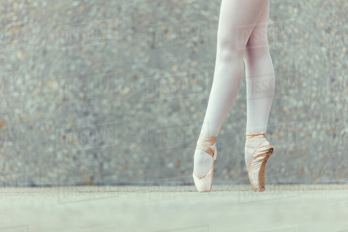 Closeup shot of legs of a female ballet dancer standing on her toes ...
