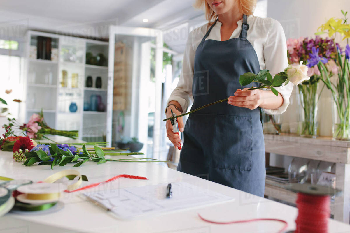 Skillful female florist creating bouquet of flowers. Young woman ...