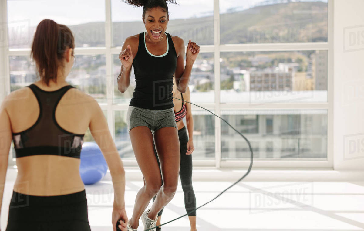 Diverse women jumping rope and having fun in studio. Female enjoying ...