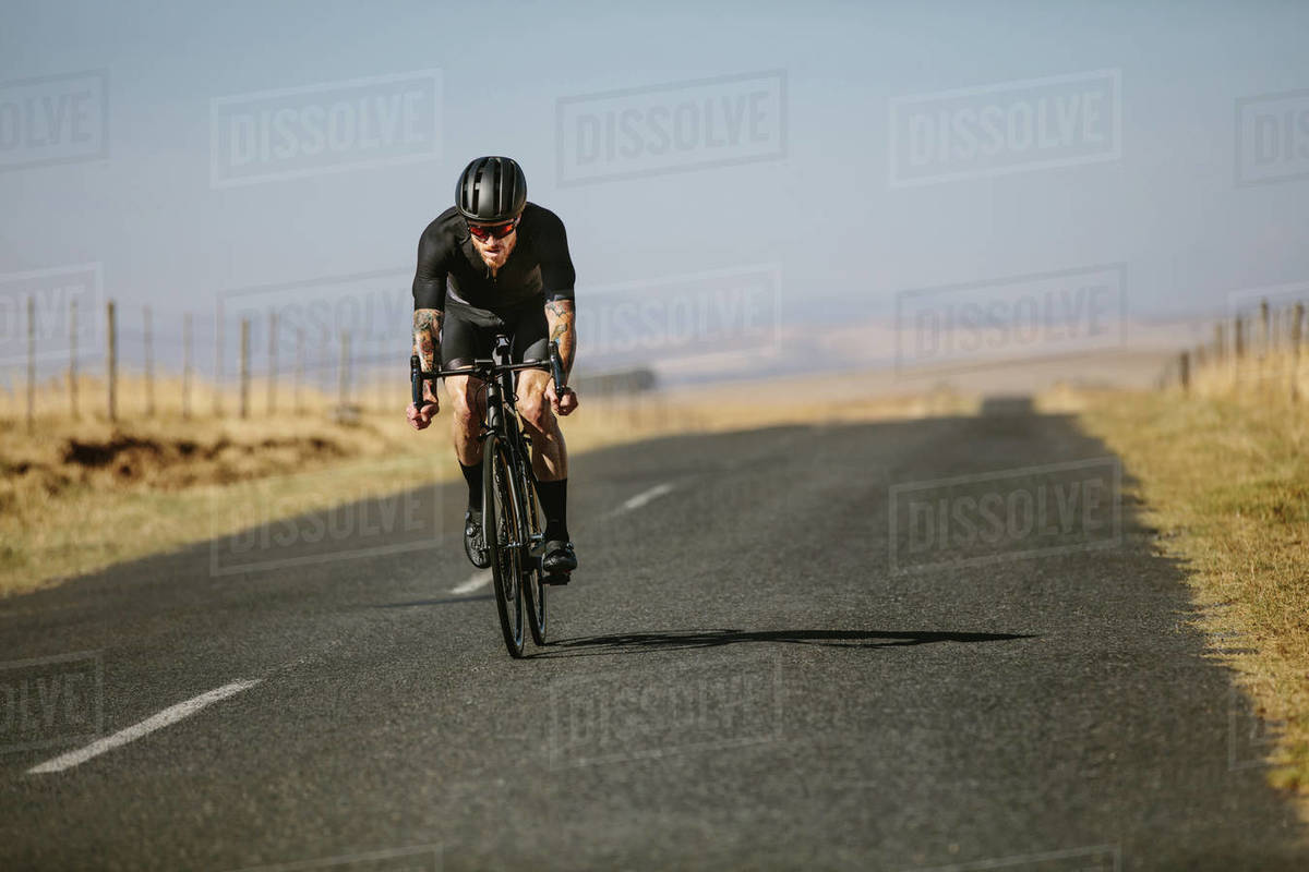 Athlete practising for cycle race on the country road. Racer riding a ...