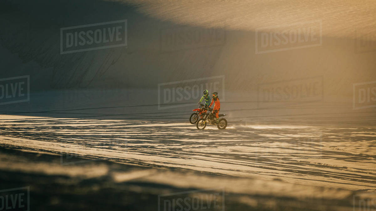 Motorcycle riders racing on the off-road terrain. Dirt bikers racing ...