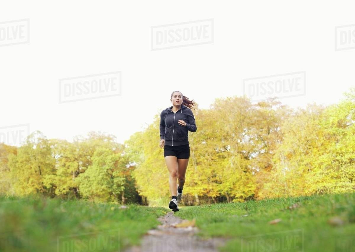 Fit and helathy young woman running outside in park. Fitness model in ...