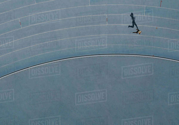 Sprinter running on athletic track. Top view of a sprinter running on ...