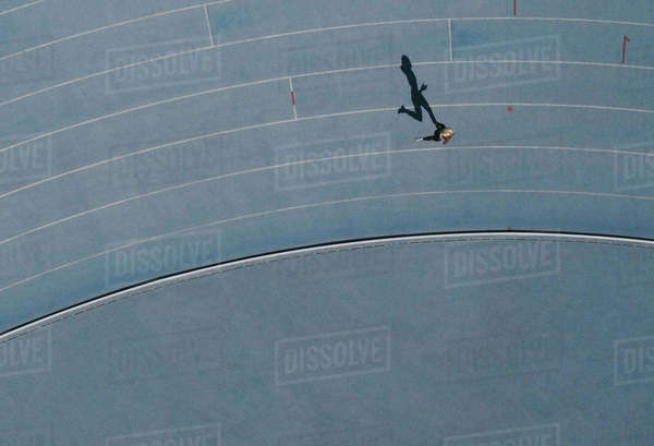 Aerial view of a woman athlete running on athletic track. Overhead view ...