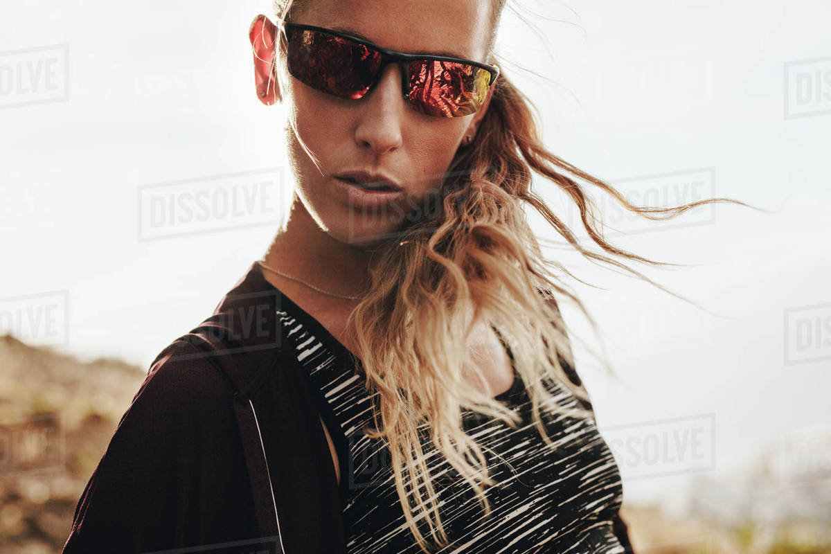Close up portrait of sportswoman with sunglasses looking at camera ...