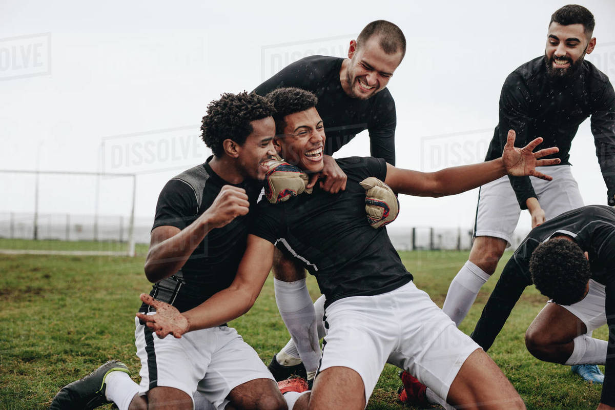 Football players celebrating success on the field. Happy footballer ...