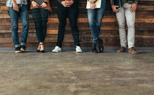 Group of people leaning against the wall before a job interview with ...