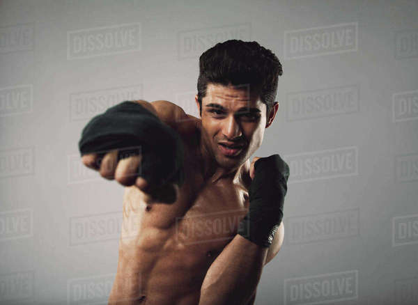 Tough young man doing some shadow boxing. Shirtless muscular man on ...