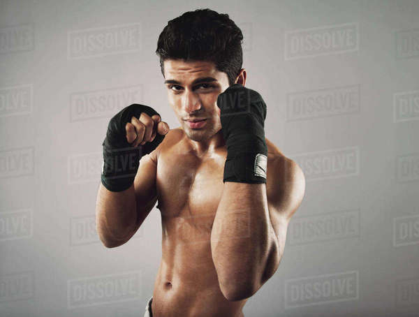 Portrait of handsome young man shadow boxing to stay fit. Studio shot ...