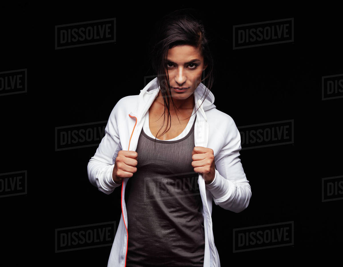 Young woman looking at camera with an attitude. Fitness female model in ...